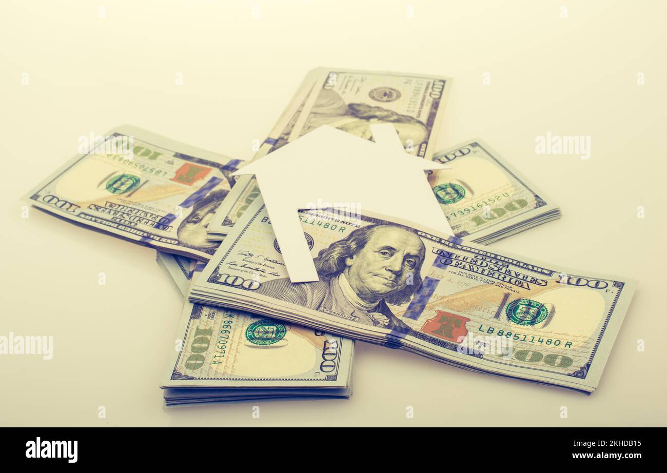 Paper house placed beside a bundle of US dollar banknote Stock Photo ...