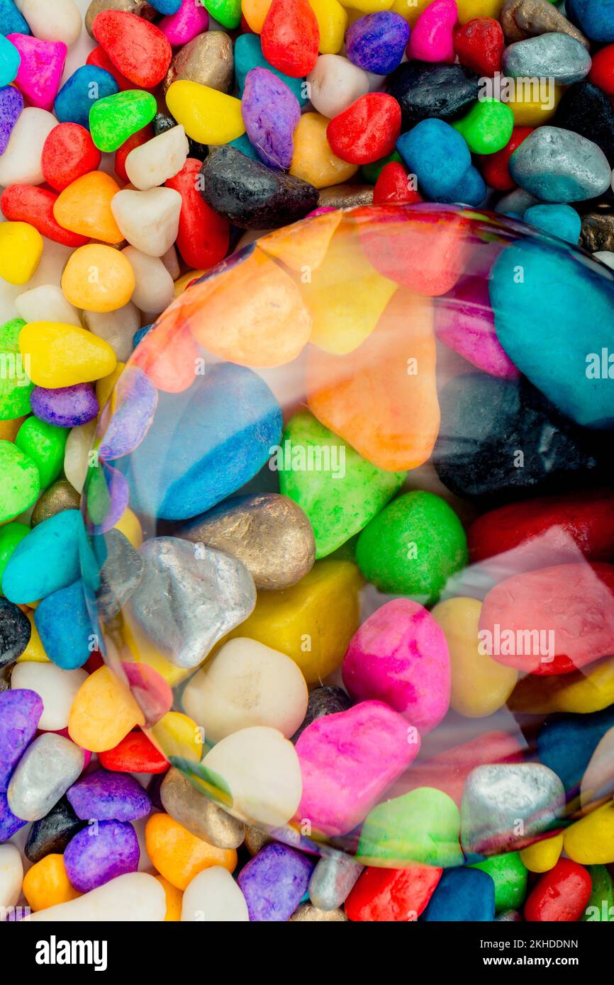 Little colorful stones as a background under a lens Stock Photo - Alamy