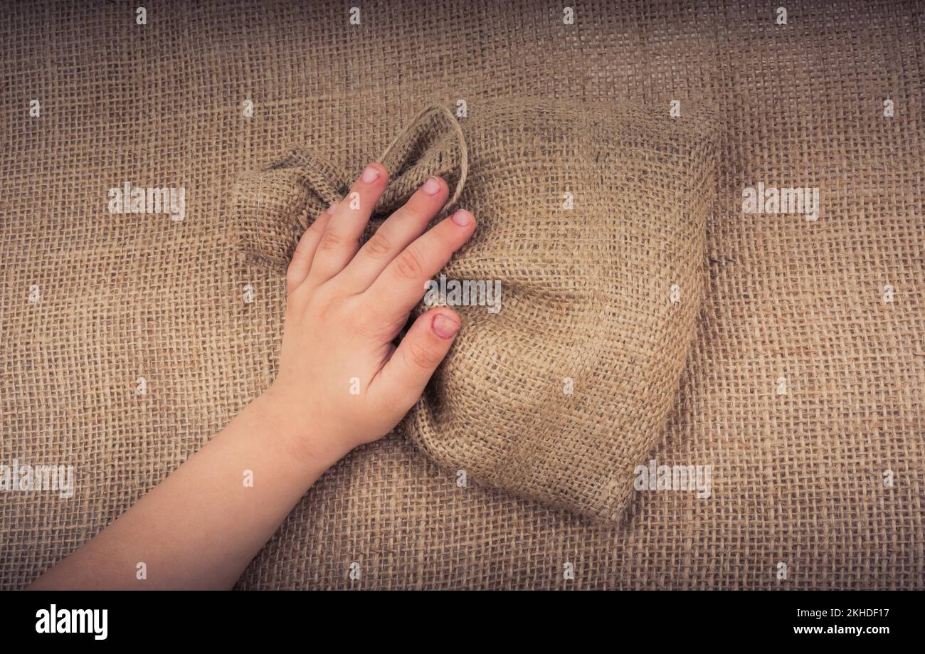 Hand holding an empty little sack made of linen Stock Photo - Alamy