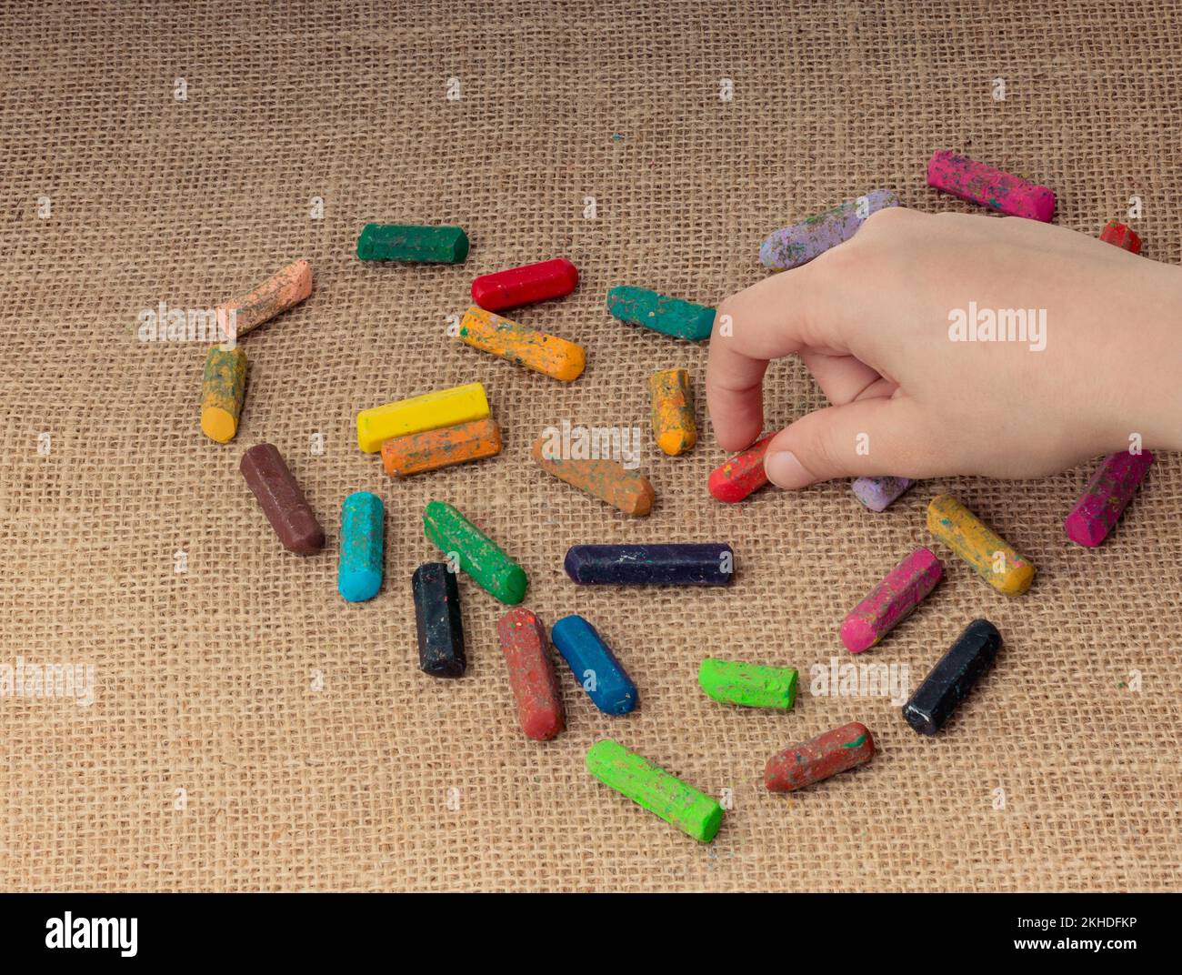 Hand holding a crayon by crayons forming a heart shape Stock Photo - Alamy