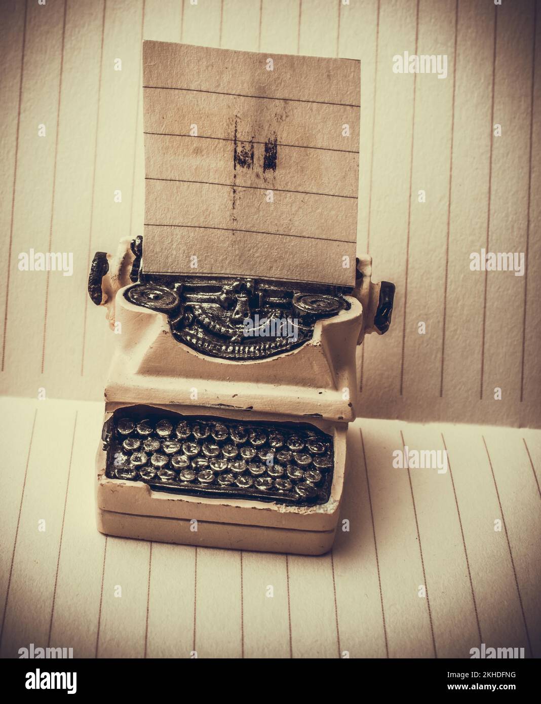 Retro syled tiny typewriter model on a paper background Stock Photo - Alamy