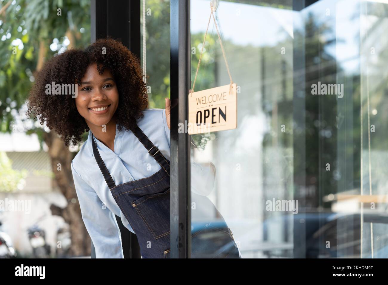 Small business african female owner smiling while turning sign for ...