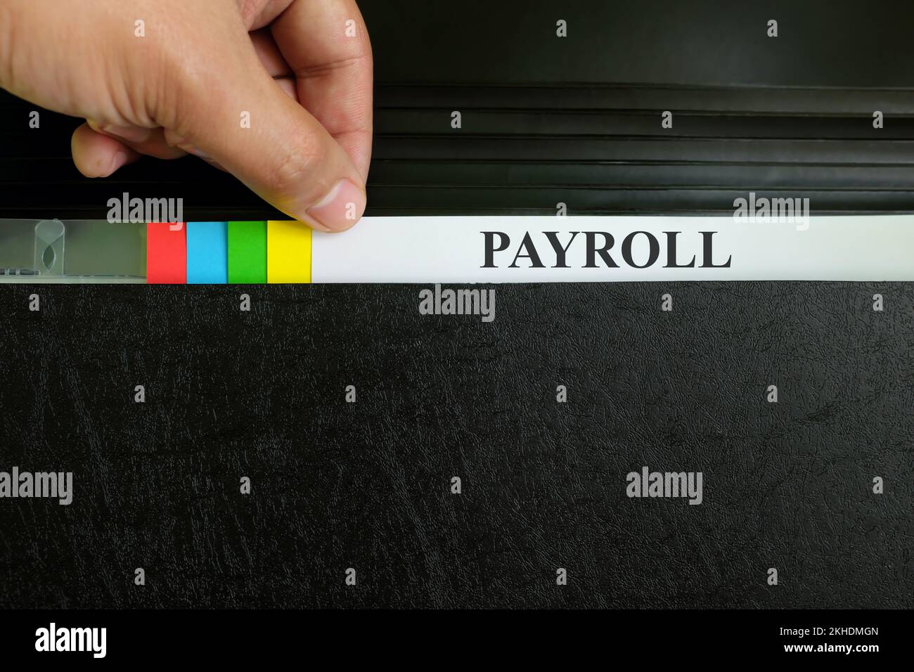 Hand picking payroll file in black binder folder. Human resources and ...
