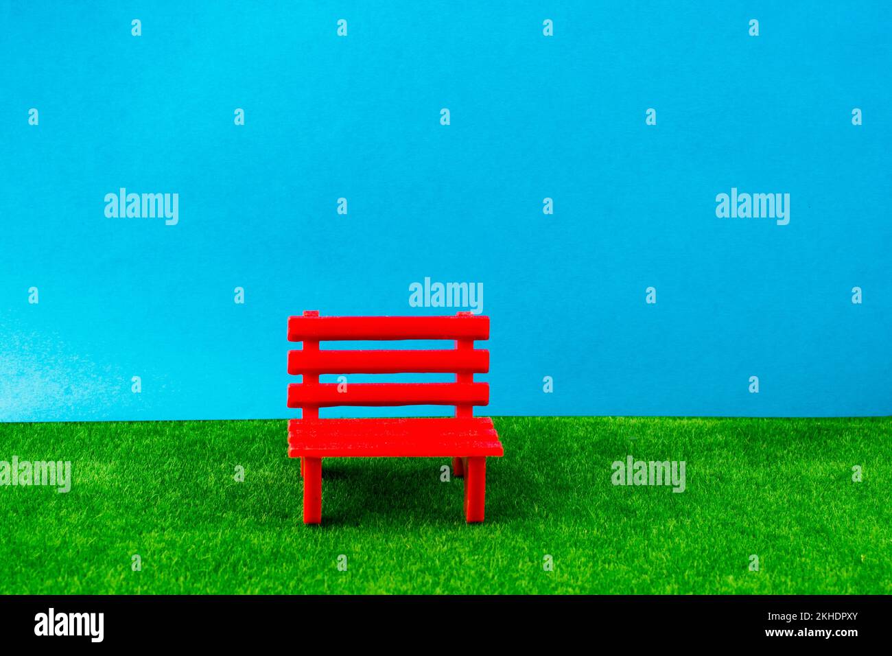 Little red miniature bench made of plastic Stock Photo - Alamy