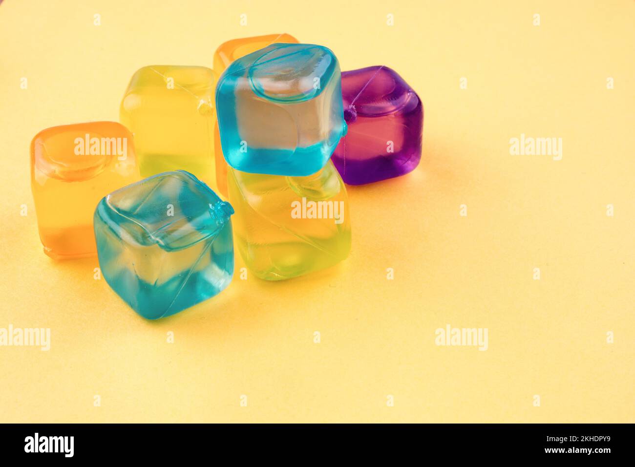 Fake colorful ice cubes in on a yellow background Stock Photo - Alamy