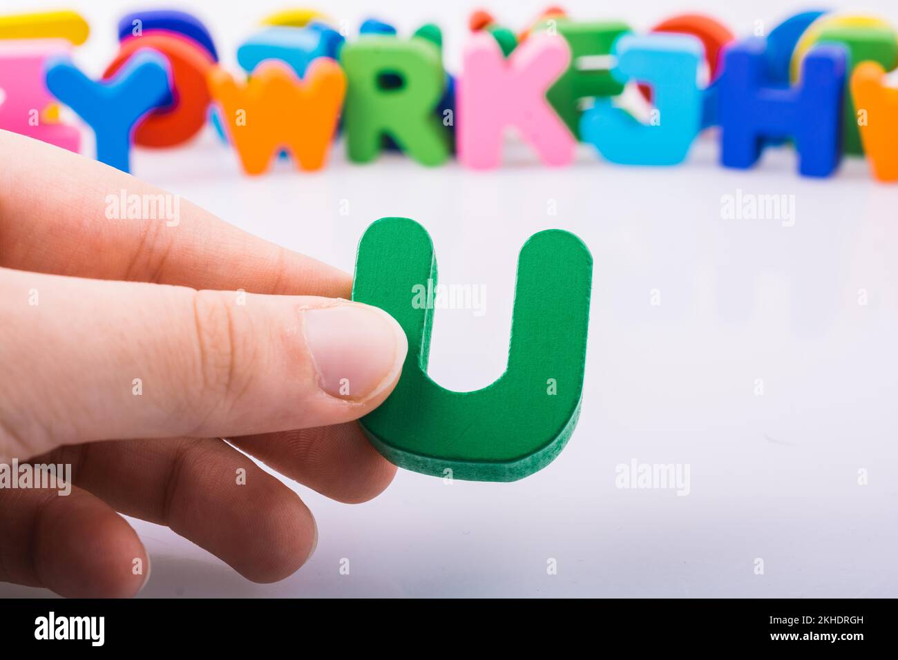 Hand holding letter cube U of made of wood Stock Photo - Alamy
