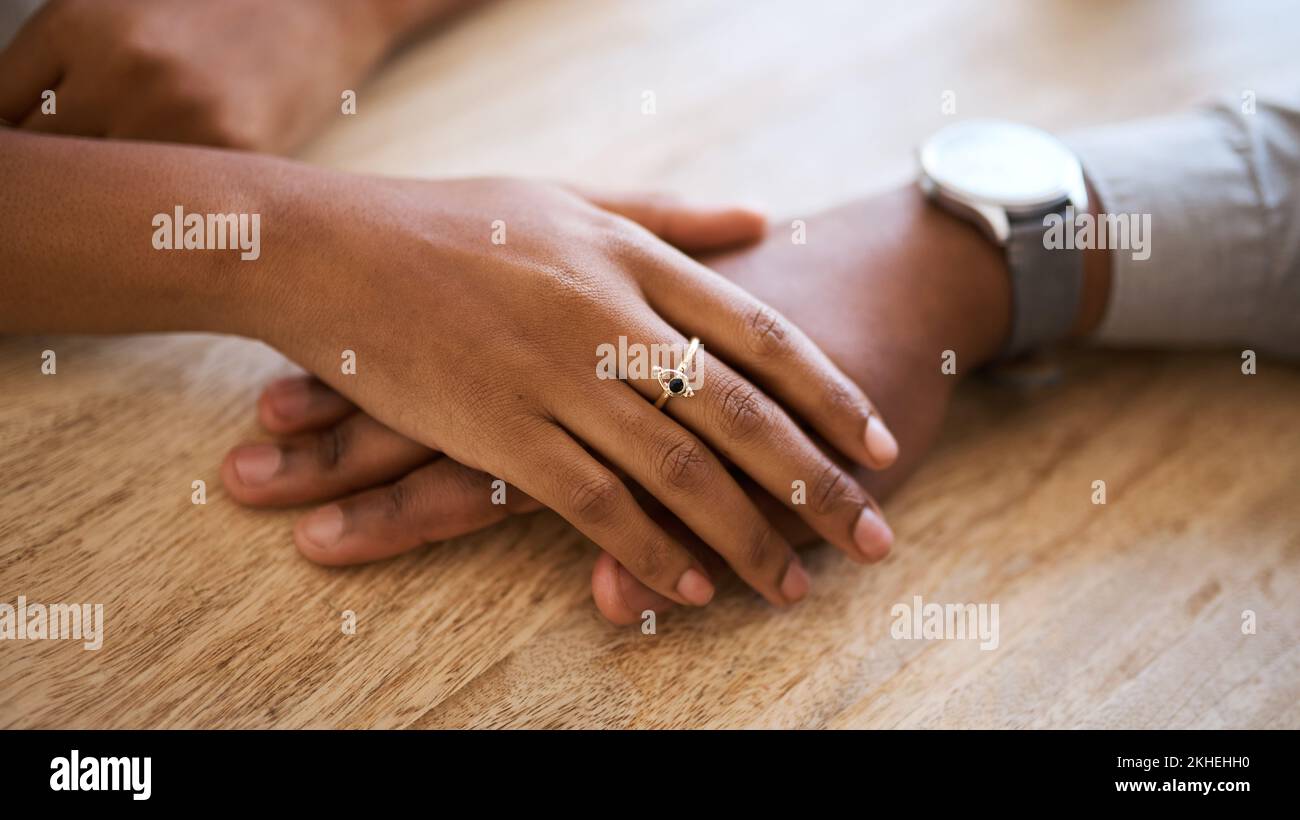 Couple, hands and support with love and trust zoom against wood table ...