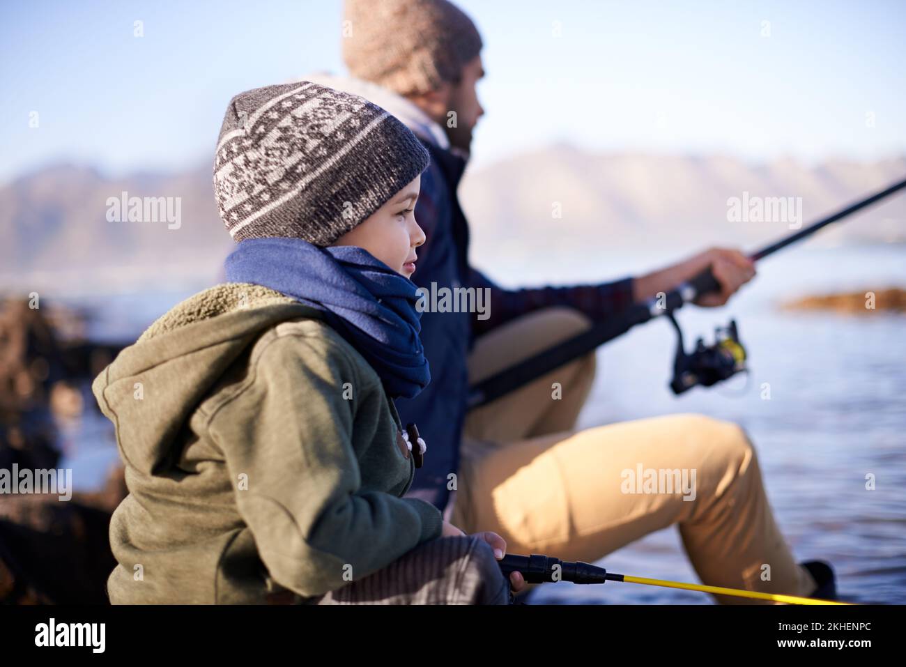 Ill beat dad in no time. a cute little boy fishing with his father by ...