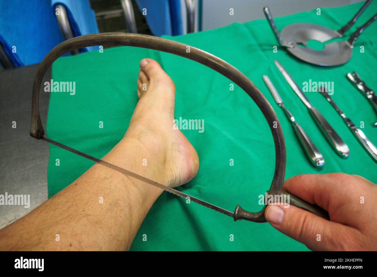 an amputation saw is applied to one leg in an operating room Stock ...