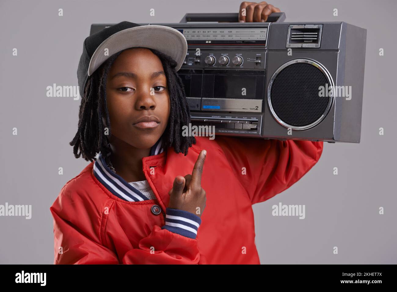 Can you hear that. Studio shot of a young boy dressed in hip hop attire ...