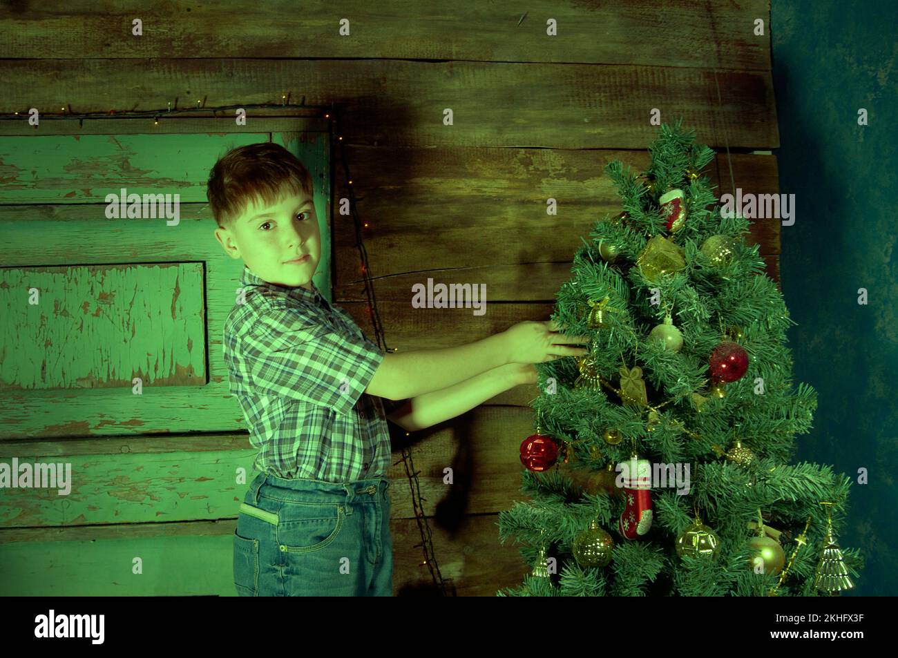 Happy little Boy decorate Christmas tree in beautiful living room with ...
