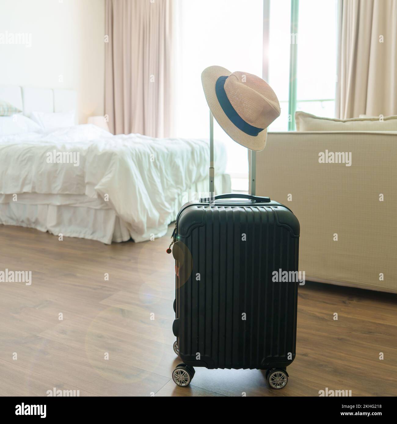 Black Luggage with hat in modern hotel room after door opening. Baggage ...