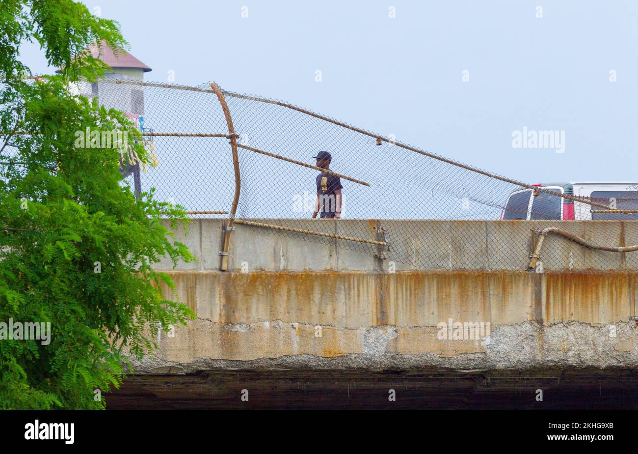 A young African American man walks along a blighted section of Gratiot ...