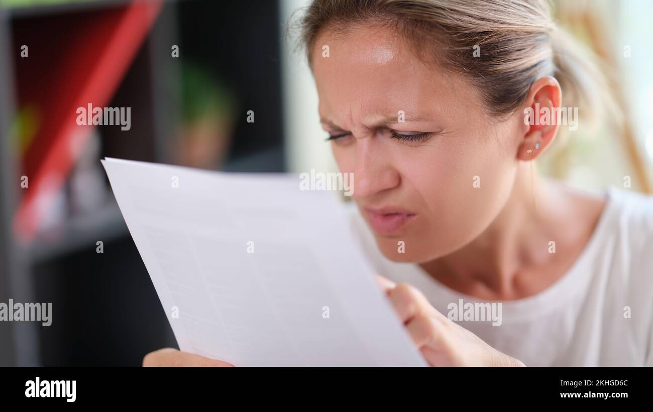 Concentrated female read papers, squinting to see more clearly Stock ...