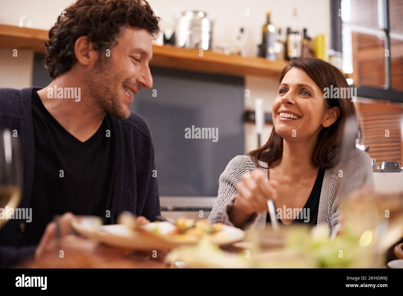 How was your day. a happy couple sitting down to dinner Stock Photo - Alamy