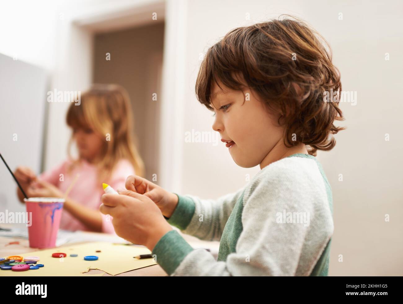 Crafty little fellow. a cute little boy painting easter eggs with his ...