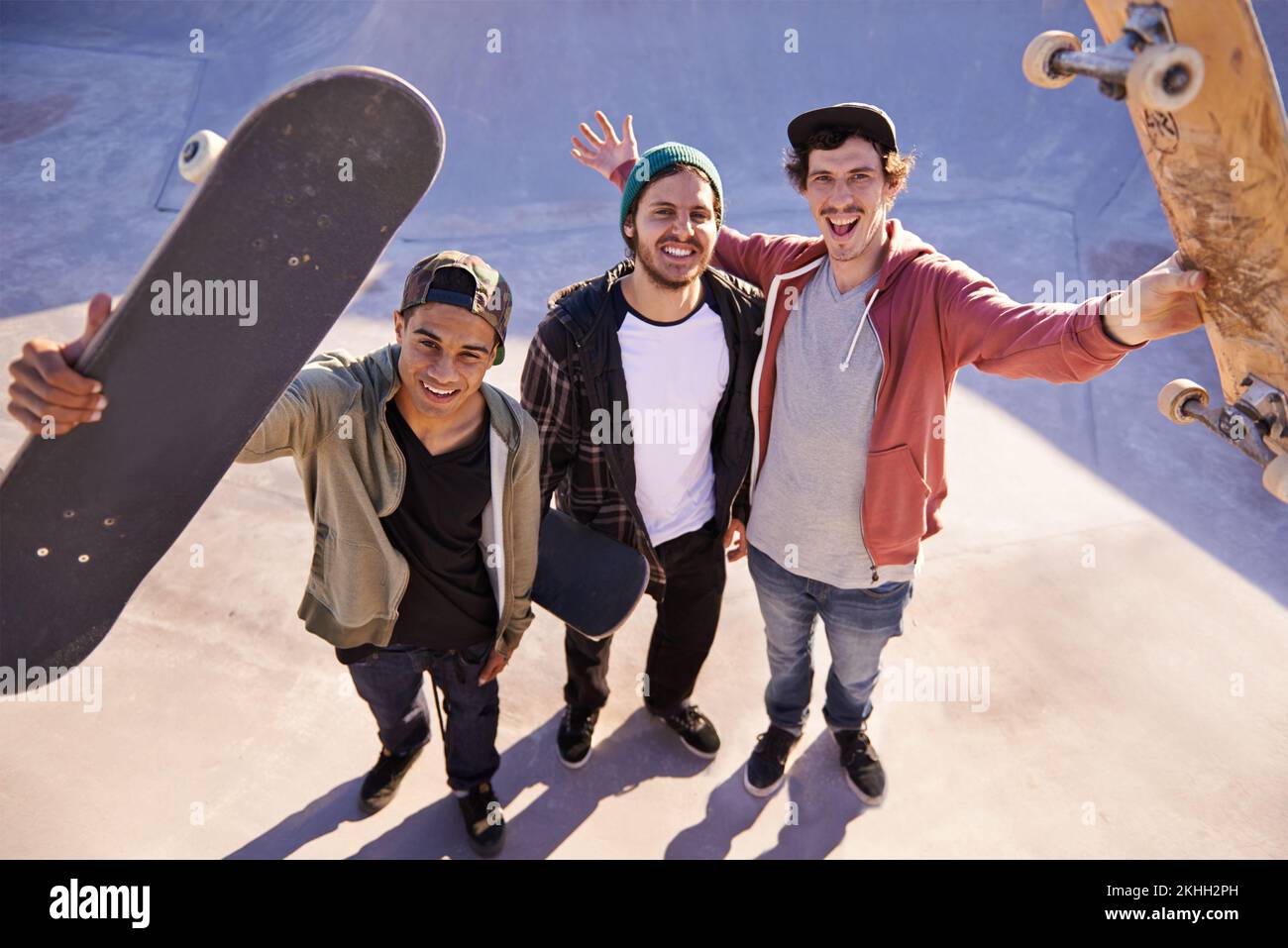 A rad day at the park. A portrait of three skater friends holding up ...