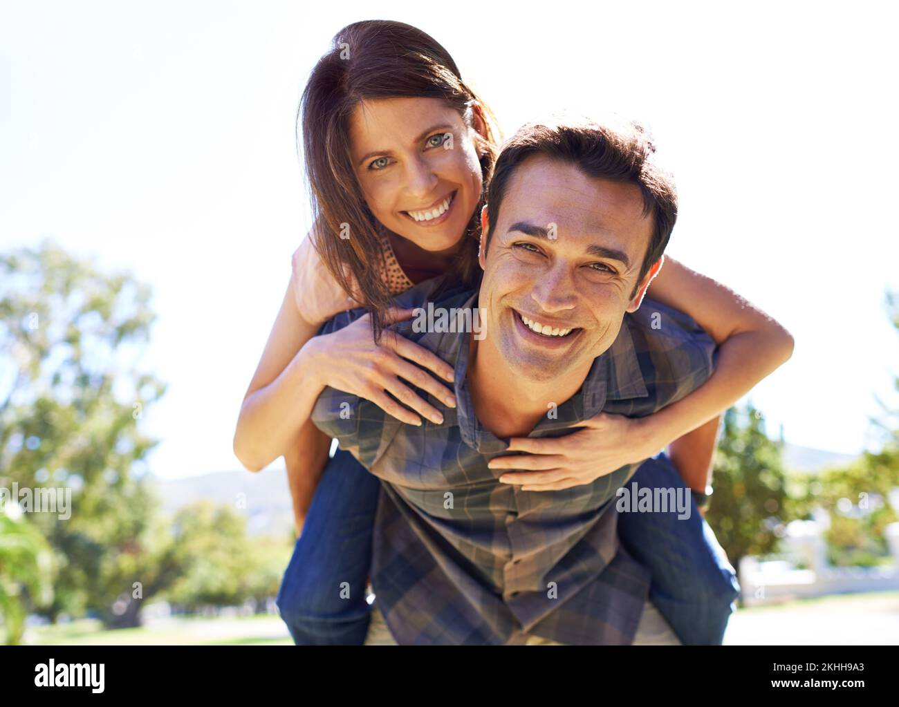 Marriage is still so much fun. a young couple being playful in the park ...