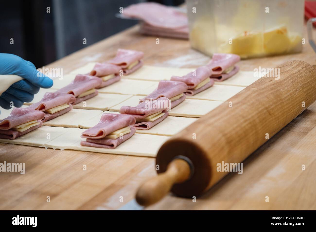 Ham is laid out on rolled-out dough during pastry making Stock Photo ...
