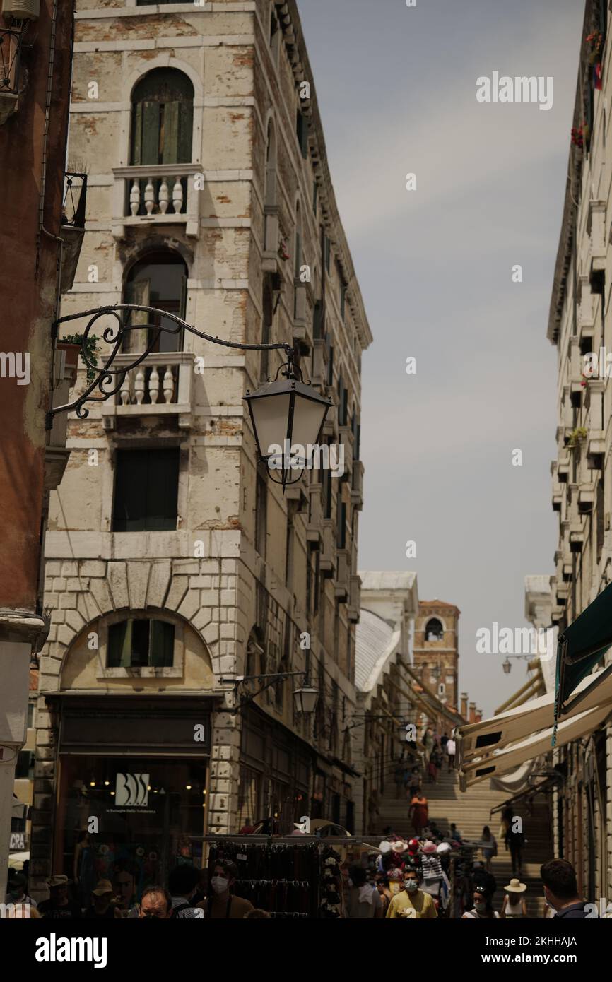A vertical shot of the crowded street between the buildings in Venice ...