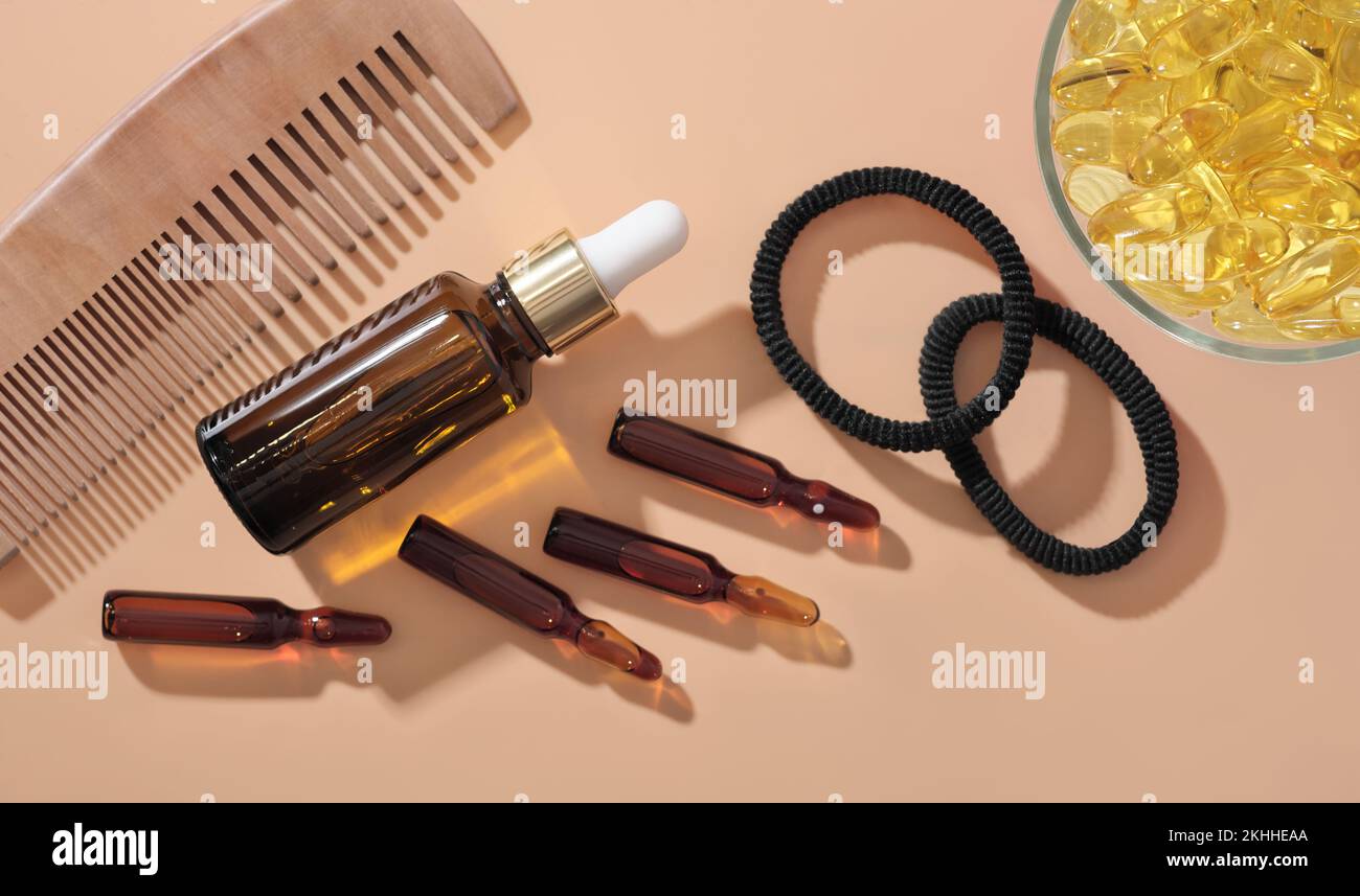 Hair growth ampules and serum solution next to omega 3 capsules and ...