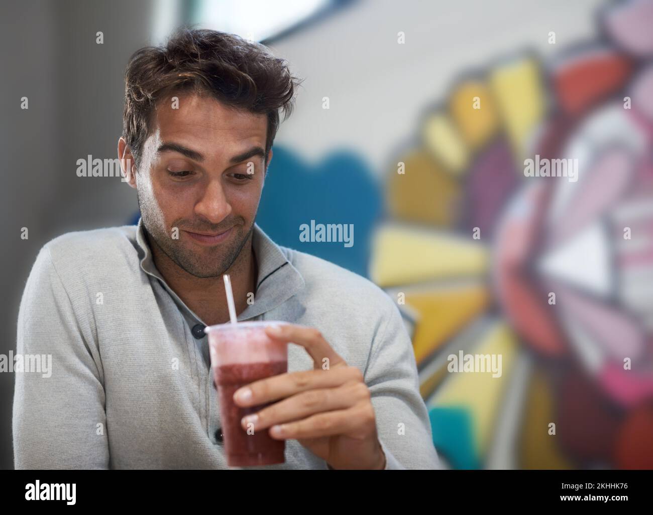 Fresh squeezed refreshment. a handsome man drinking a smoothie at a ...
