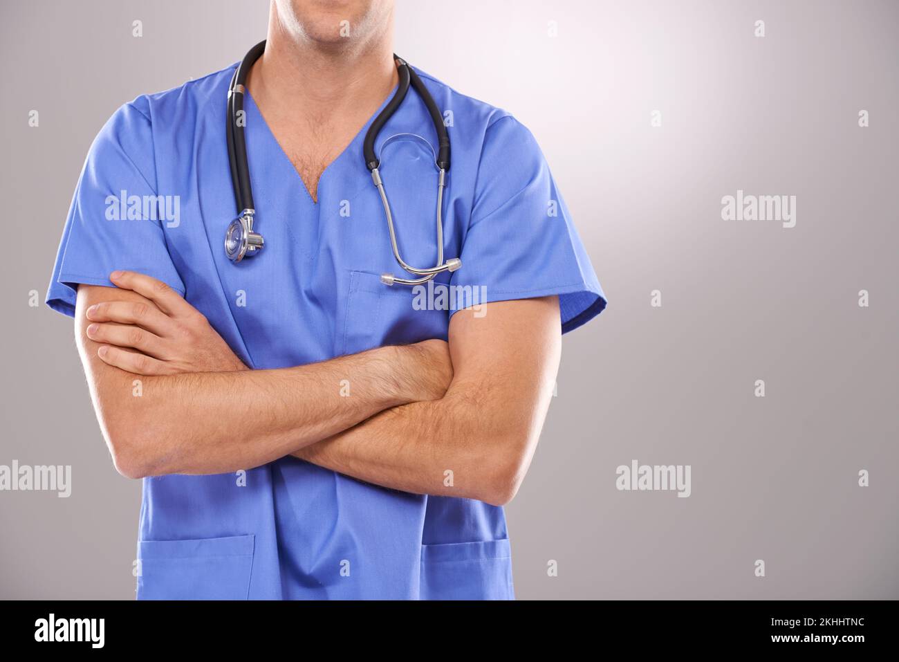 Surgery was a success. a doctor wearing scrubs with his arms folded ...