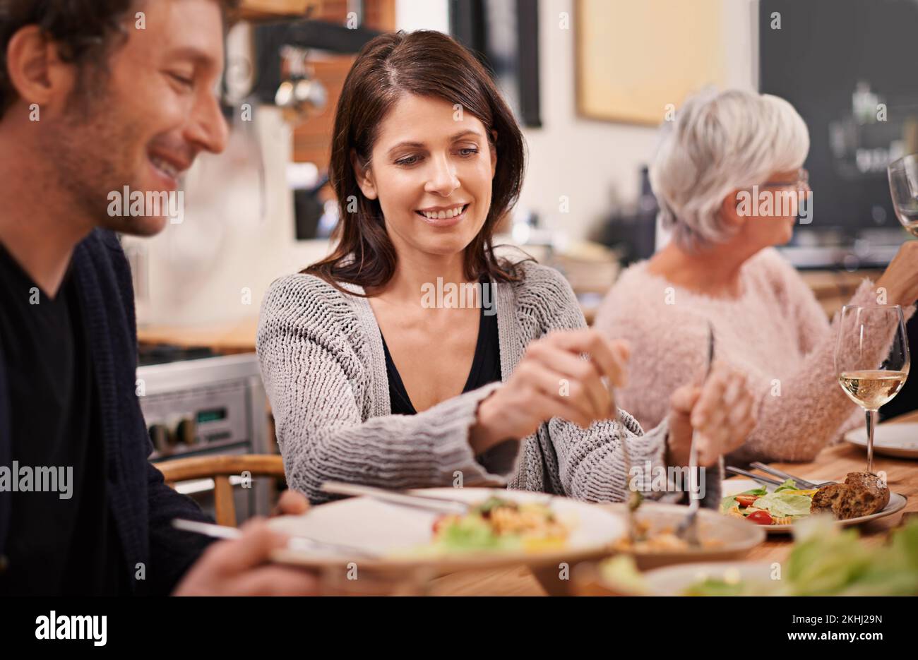 Can I dish for you. a family sitting down to dinner Stock Photo - Alamy