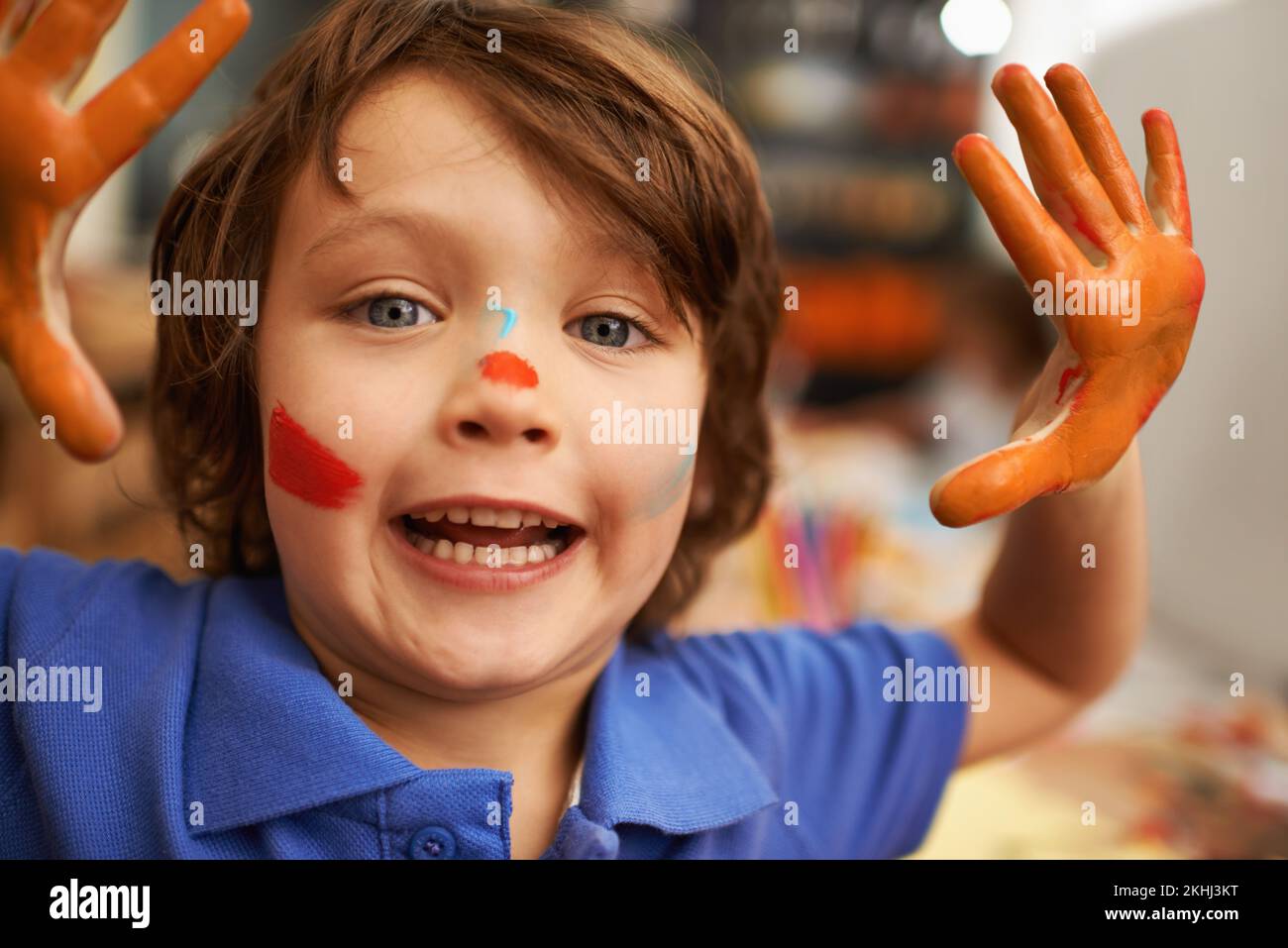 Art class mischief. Cute little boy showing his hands and paint covered ...