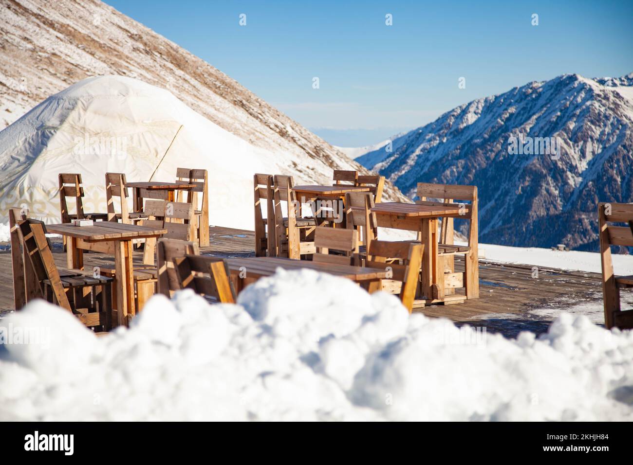 Outdoor restaurant terrace on top of a snowy mountain with wooden ...
