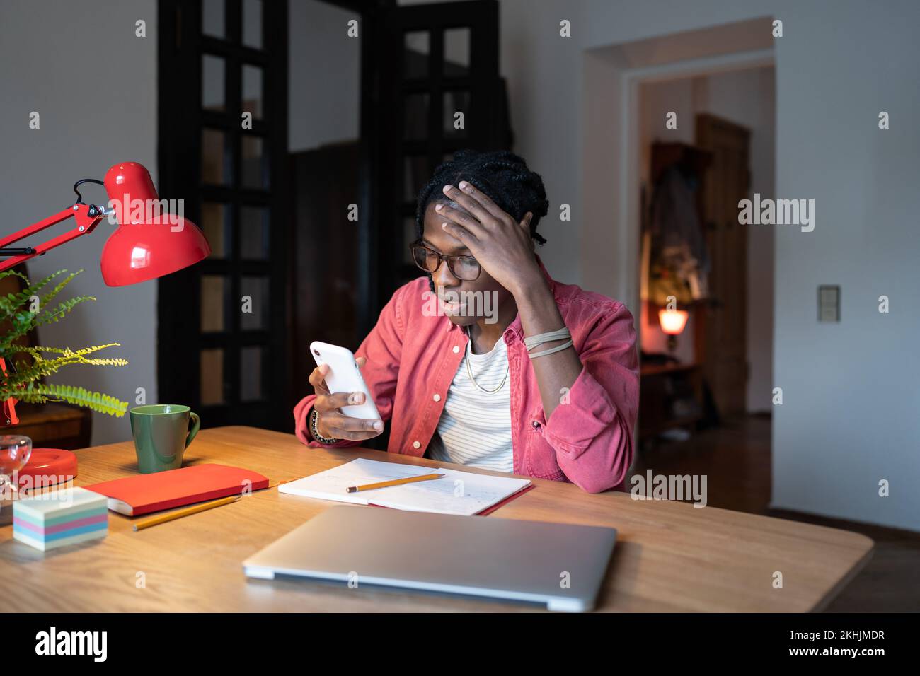 Dumbfounded confused African American man reads news in mobile phone ...
