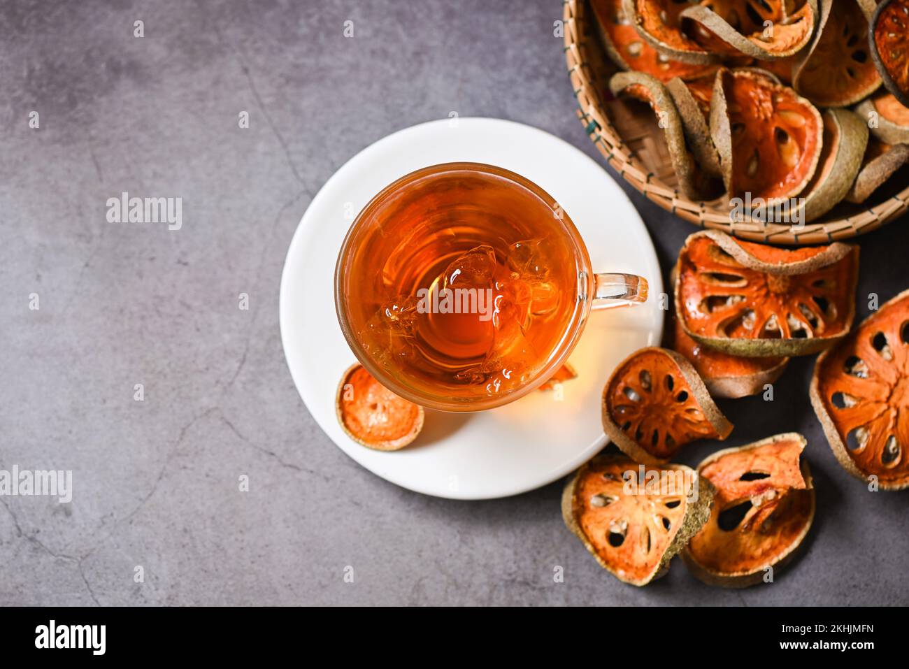 Bael tea on glass with dried bael slices on dark background, Bael juice ...