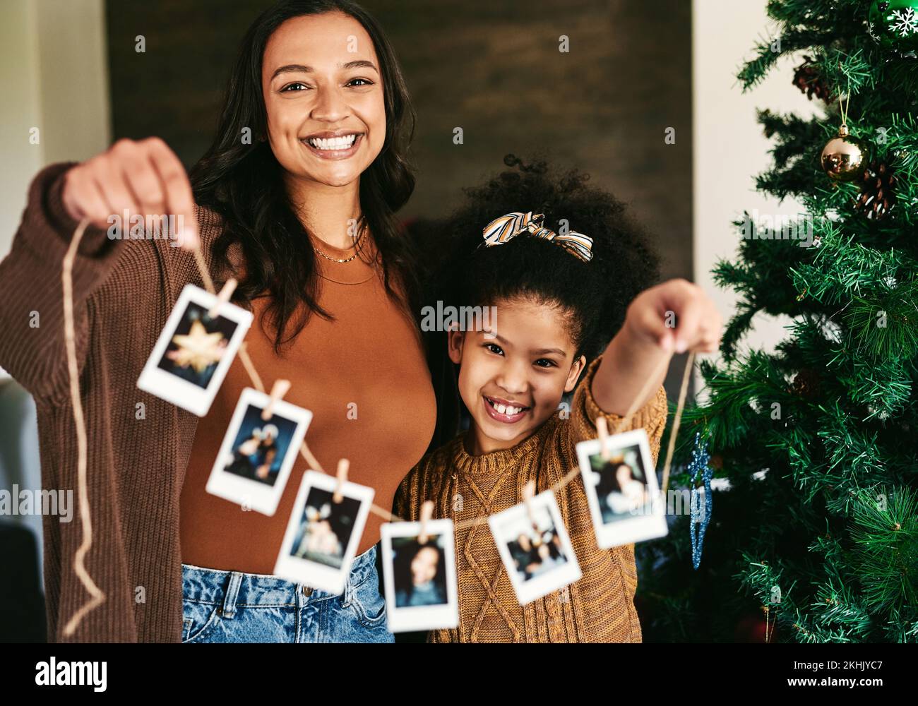 Christmas, decoration and mother and girl with Polaroid on a tree for ...