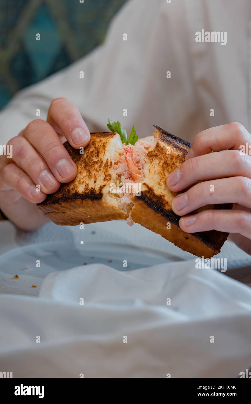 The vertical shot of someone splitting the stuffed bread with hands ...