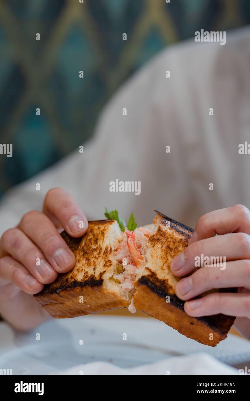 The vertical shot of someone splitting the stuffed bread with hands ...