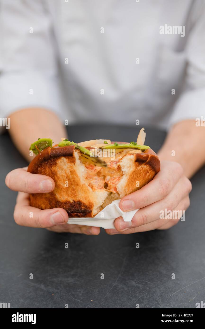The vertical high-angle shot of hands splitting the stuffed crunchy ...