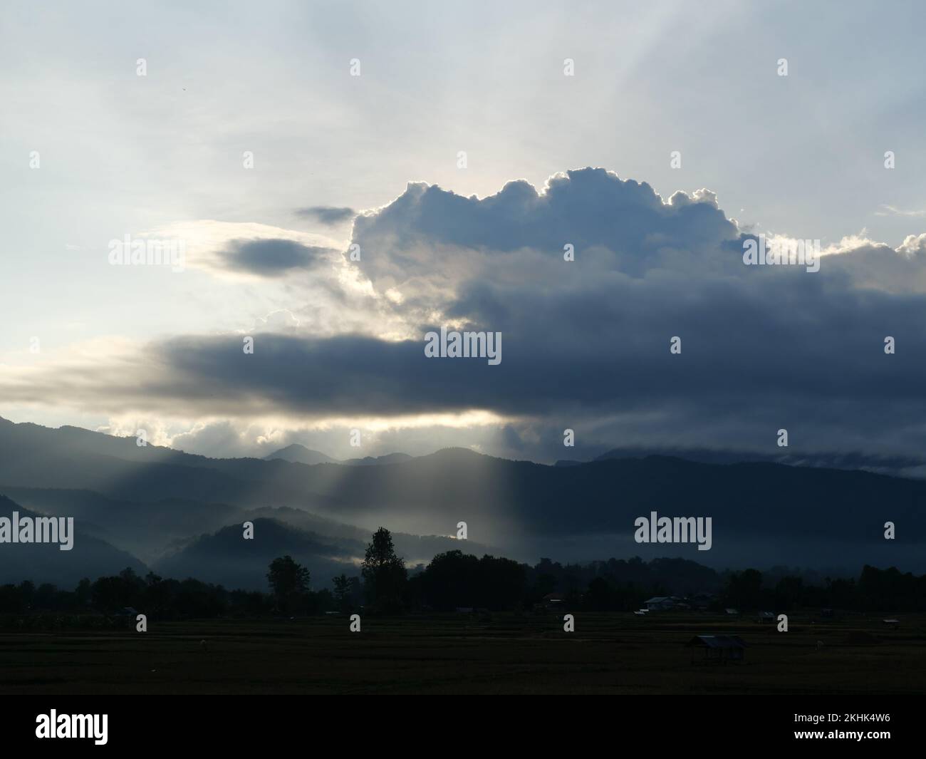 Silhouette of tree and mountain with sunbeam light shoot through the ...