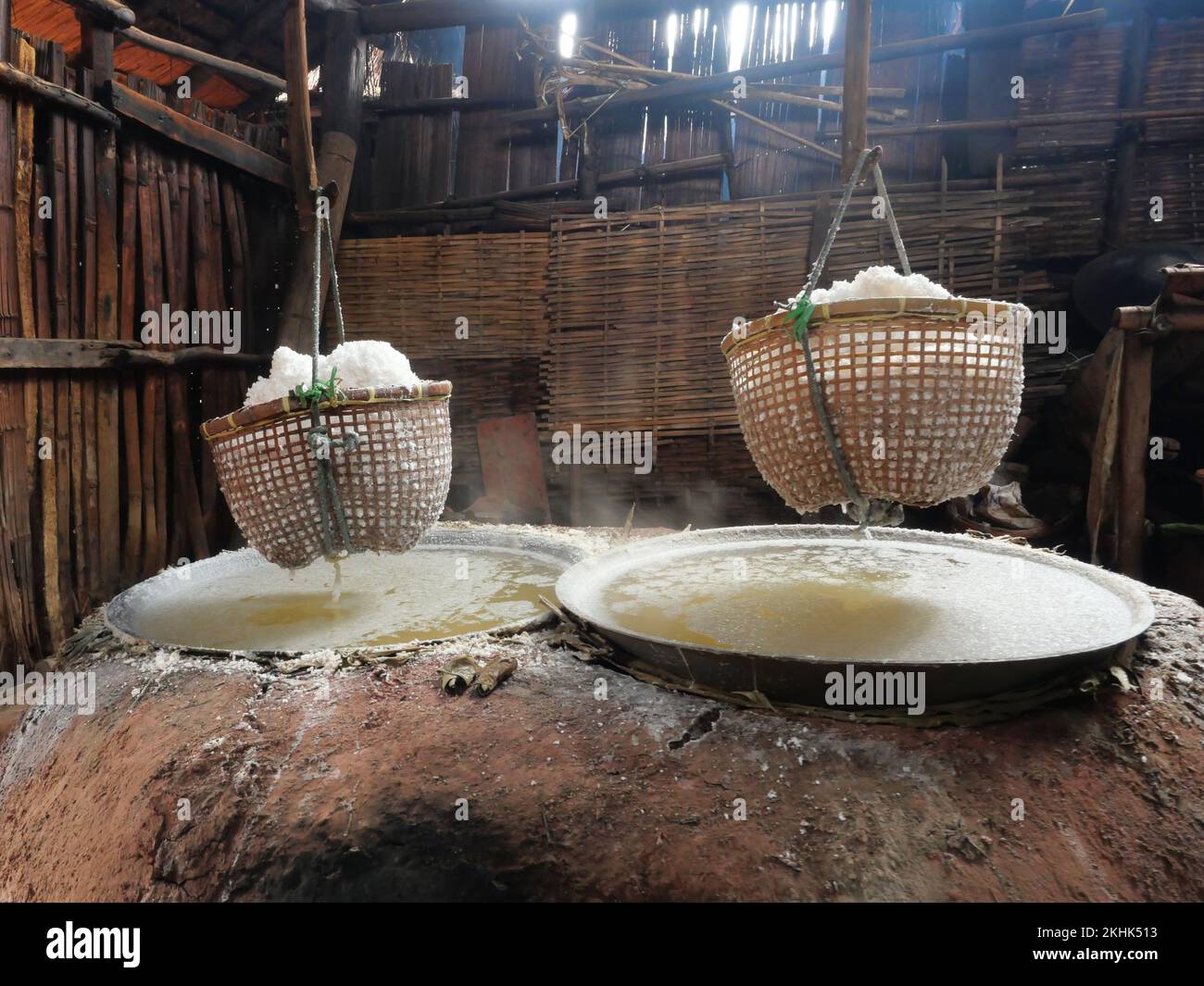 Rock salt in the basket hung above the boiling pan with white smoke and ...