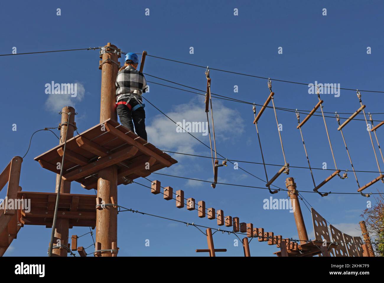 Adventure park obstacle course. Teenage girl on a difficult obstacle ...