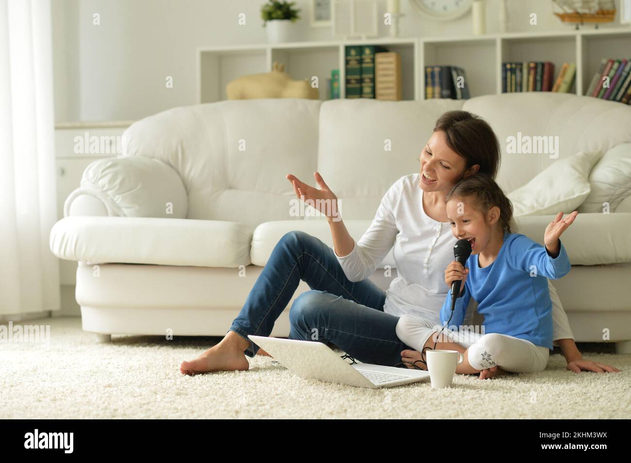 mom and daughter sing into the microphone Stock Photo - Alamy