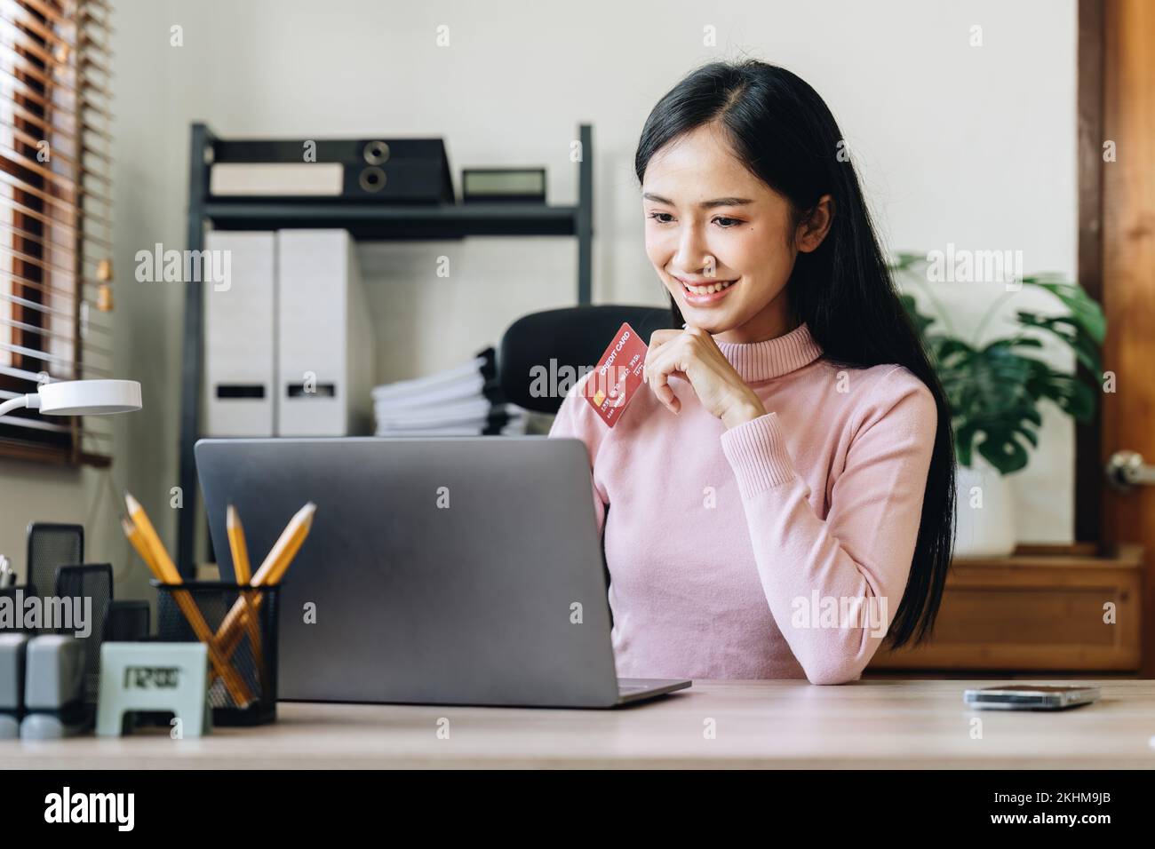 Woman holding credit card and confirm purchase via telephone call to customer service, smiling ...