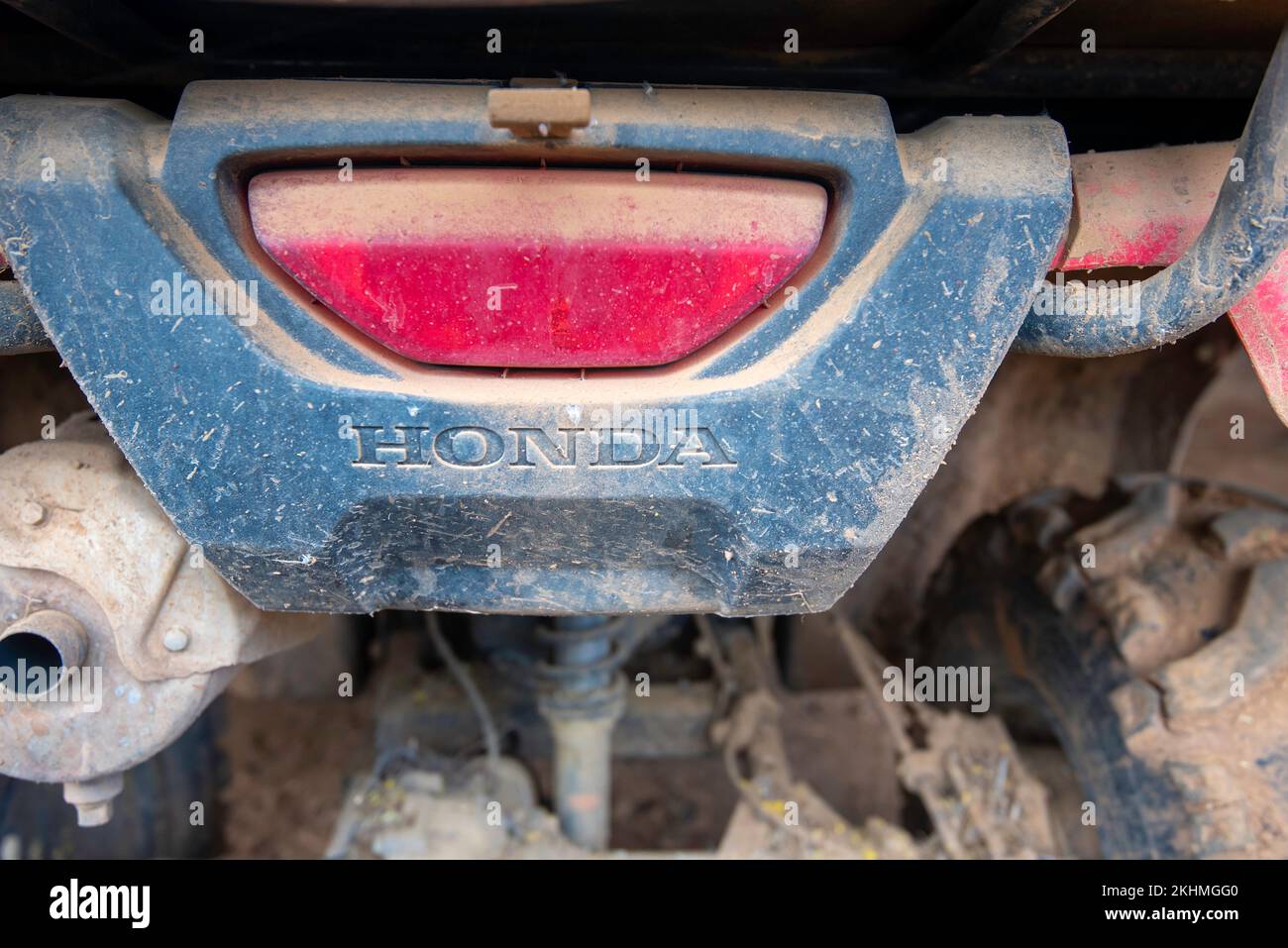 A close-up detailed view of the rear of a mud covered Honda quad bike ...
