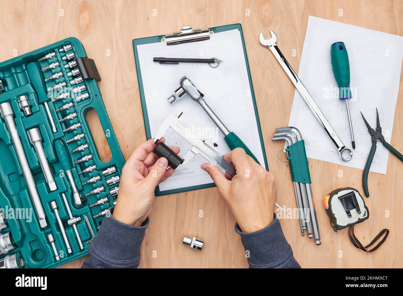 Man working in workshop using many tools. Wrench, spanner, calliper and ...
