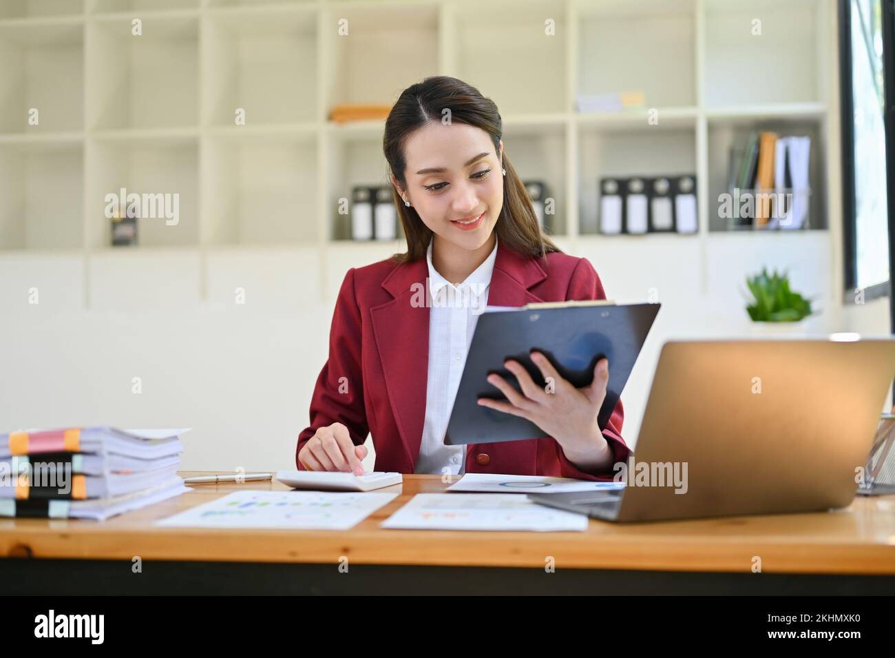 Attractive and professional Asian businesswoman or female CEO reading ...