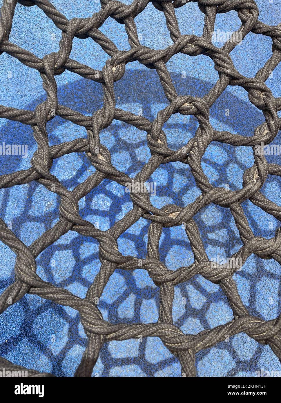 Black thick woven mesh on the blue background with a shadow from it ...