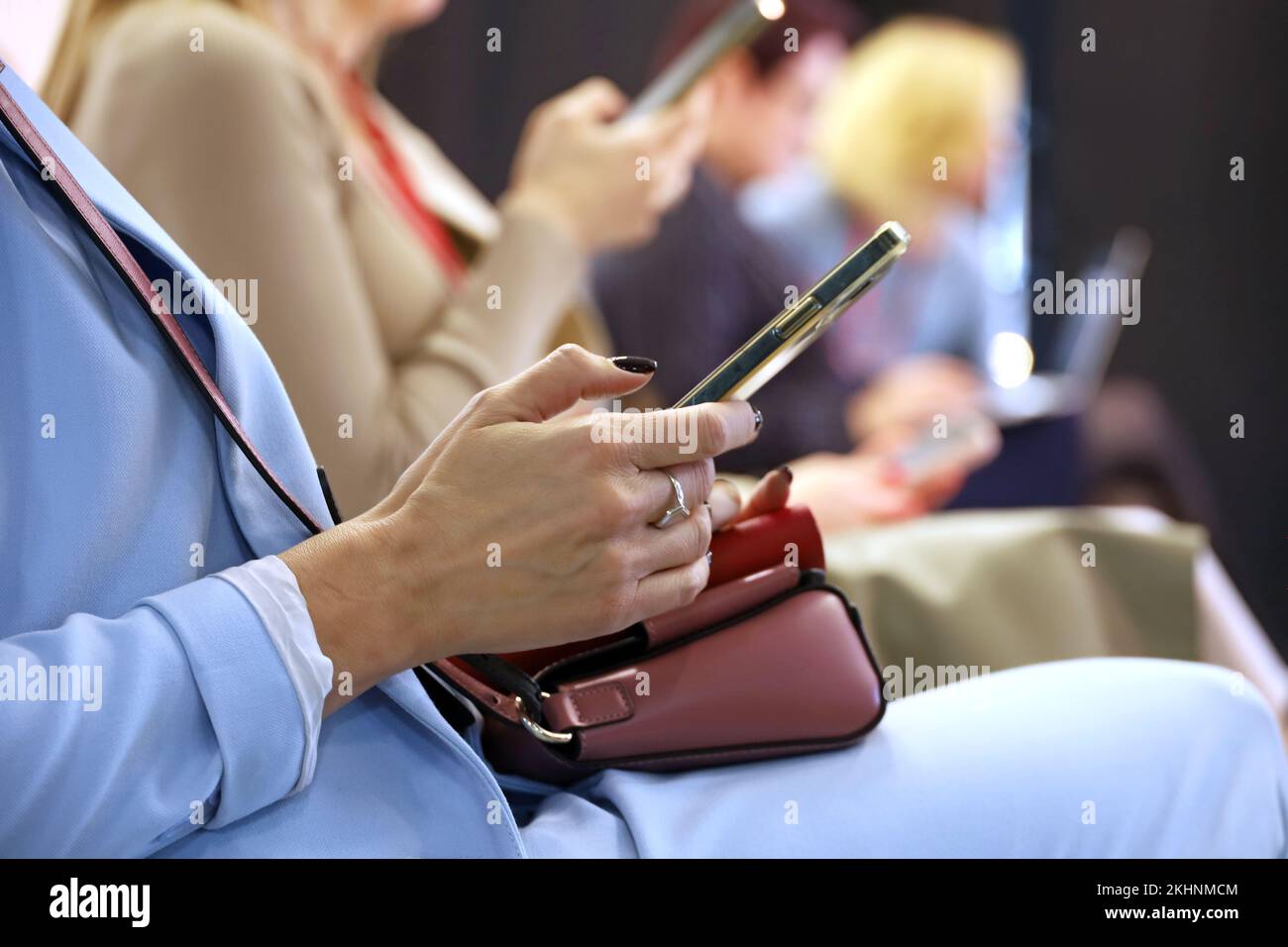 Woman using smartphone sitting indoors, mobile phones and laptops in ...