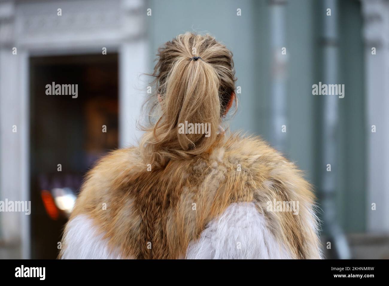 Woman with fair hair wearing fur coat on a city street. Female fashion ...