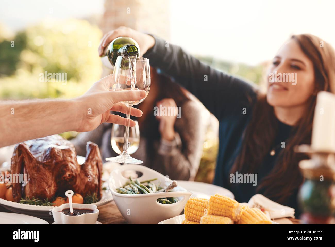 Party, dinner and woman pouring wine in a wine glass to cheers at an ...