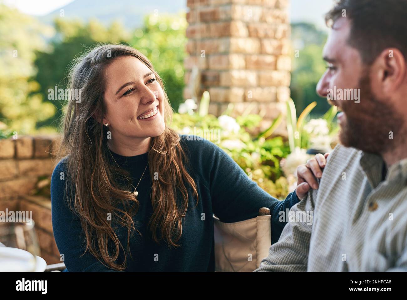 Happy, love and couple on a patio, smile and relax, laughing and ...