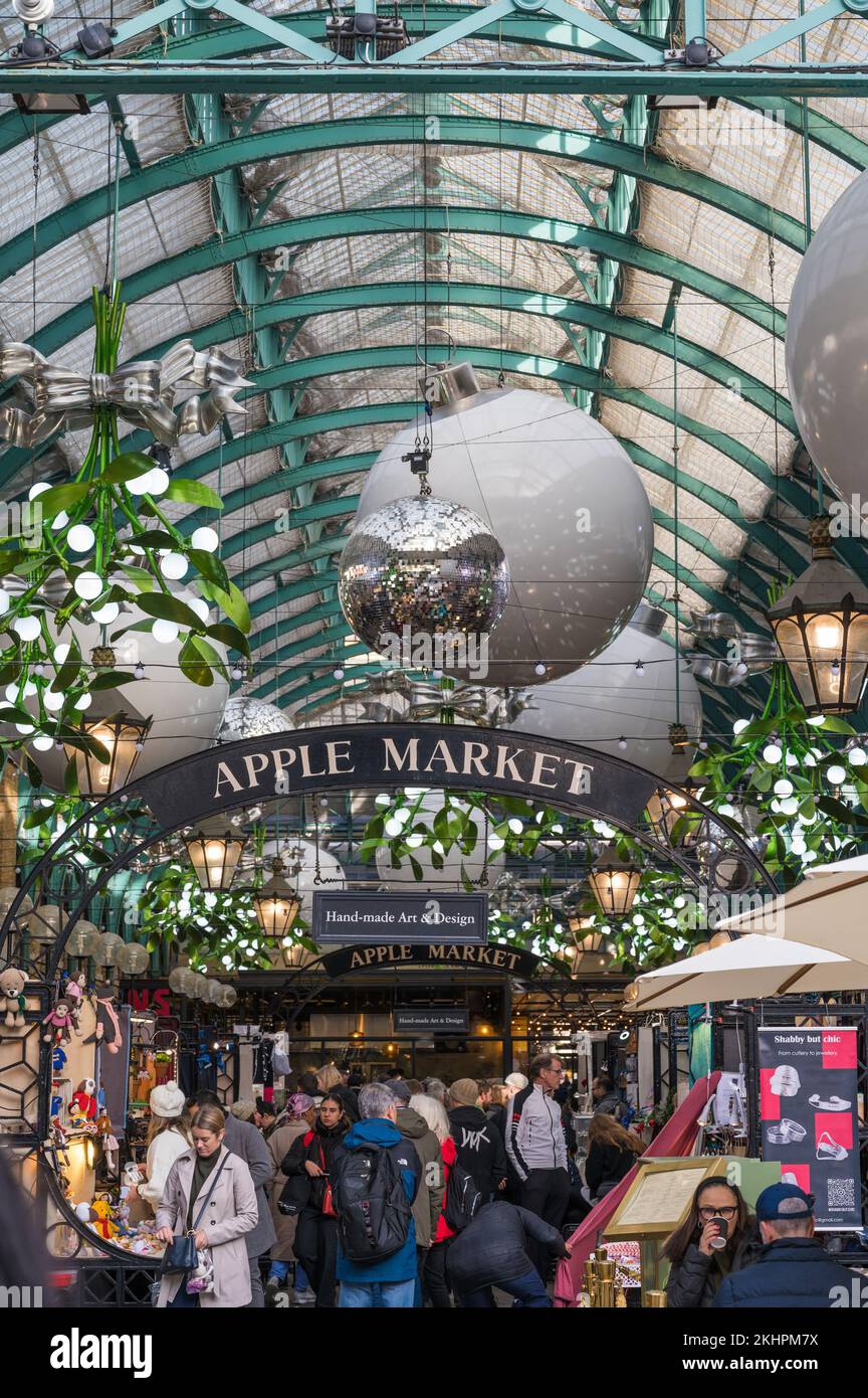 People shopping in the Apple Market. Christmas decorations hang from ...